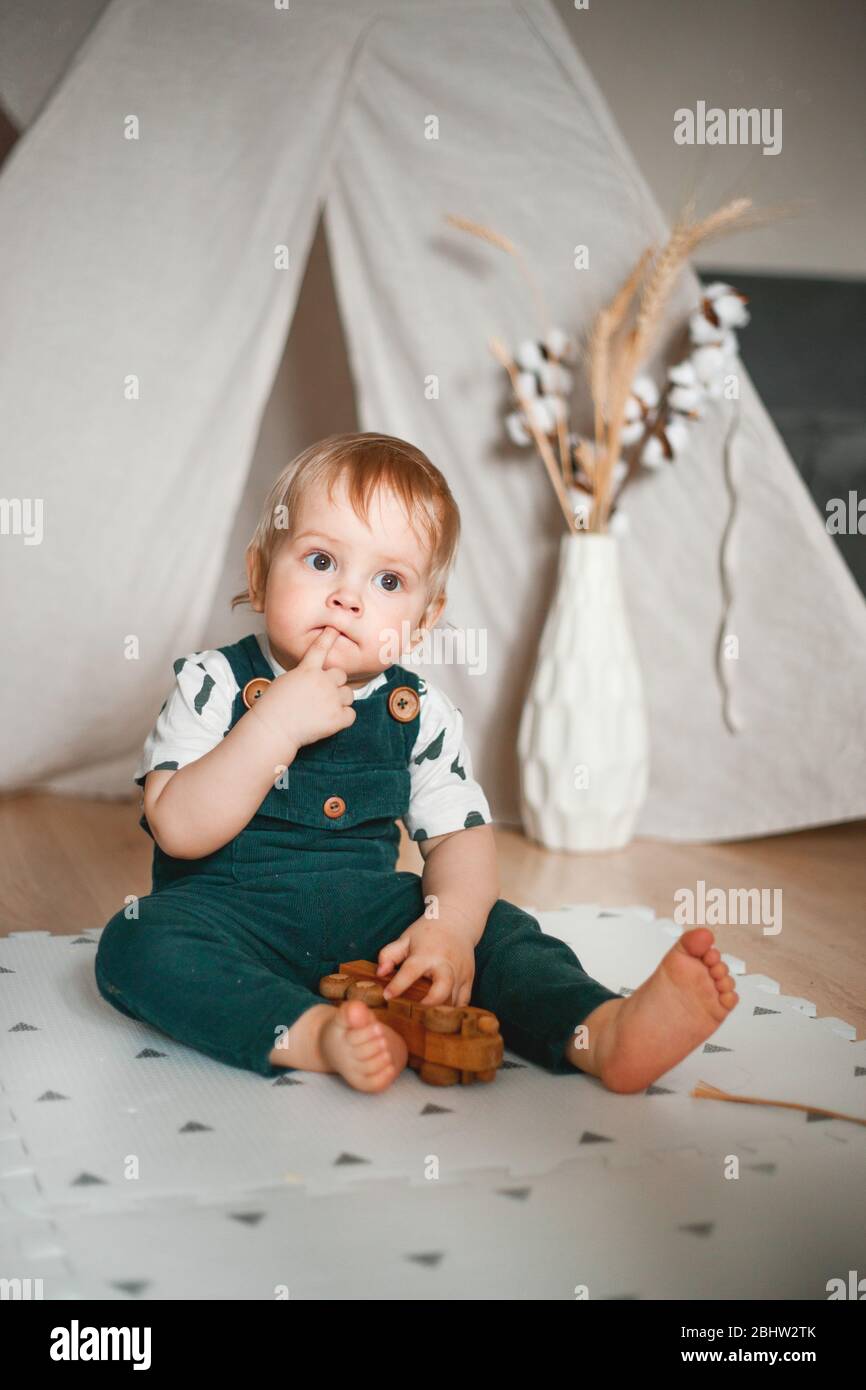 Sweet 1 year old little baby boy playing in a teepee game tent in a ...