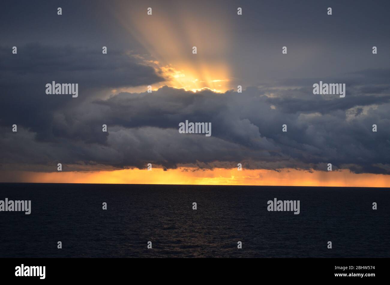 Amazing sunset with long rays piercing the clouds Stock Photo - Alamy