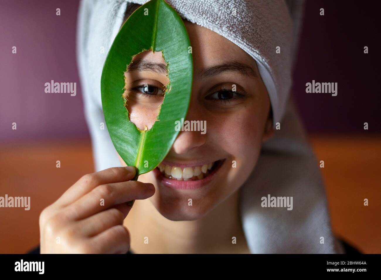 Woman looking through a leaf. Leaf in the face concept Stock Photo - Alamy