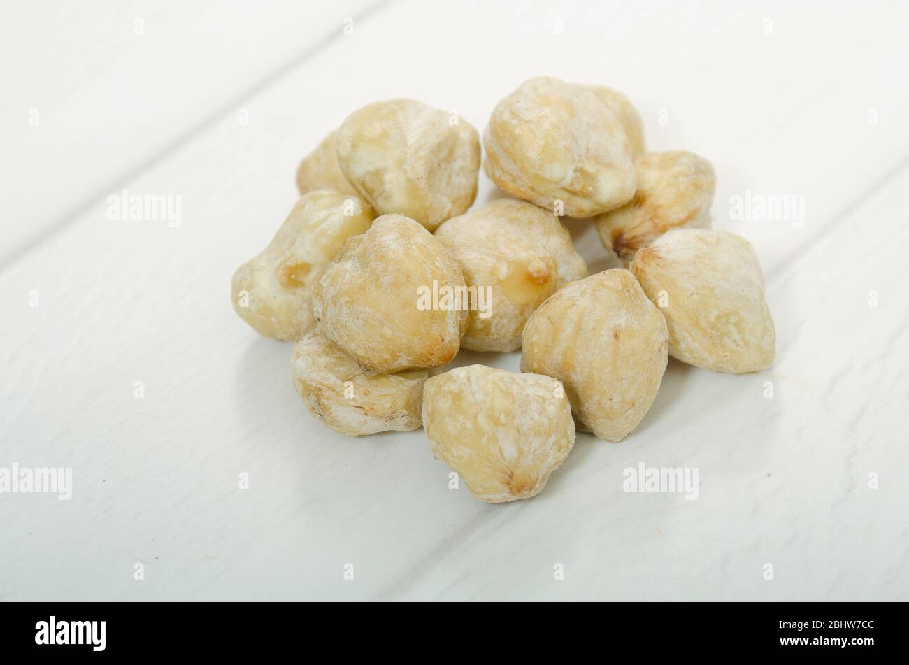 candlenut in white wooden background, used for asian and indonesian ...