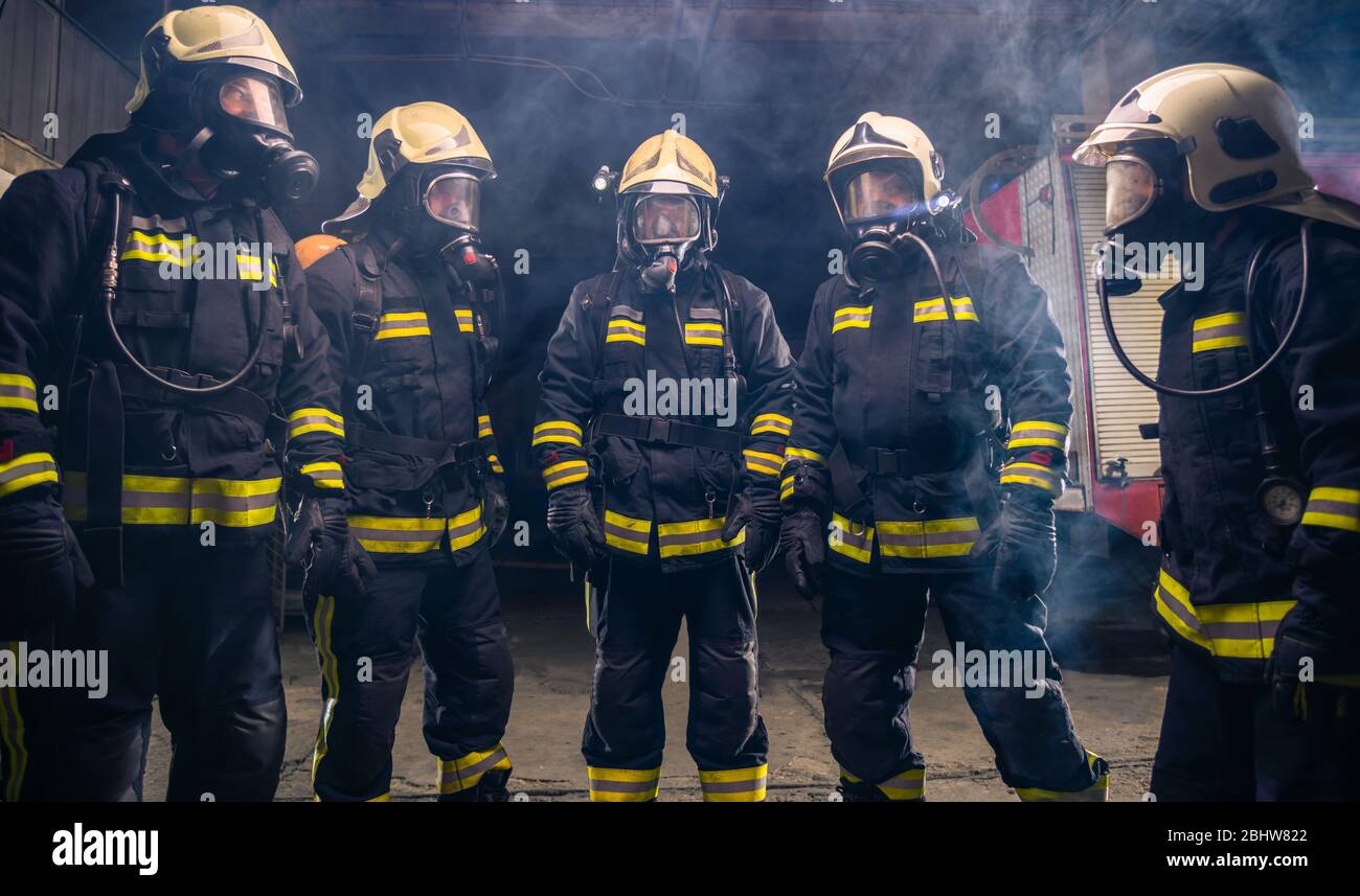 Portrait of group of firefighters in the middle of the smoke of the ...