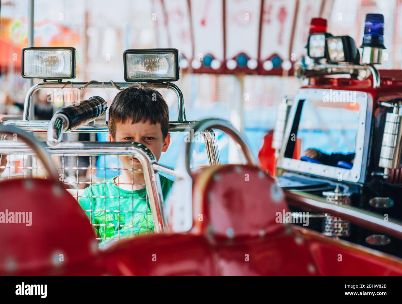 Little cheerful kid enjoying the rides at the local funfair park Stock ...