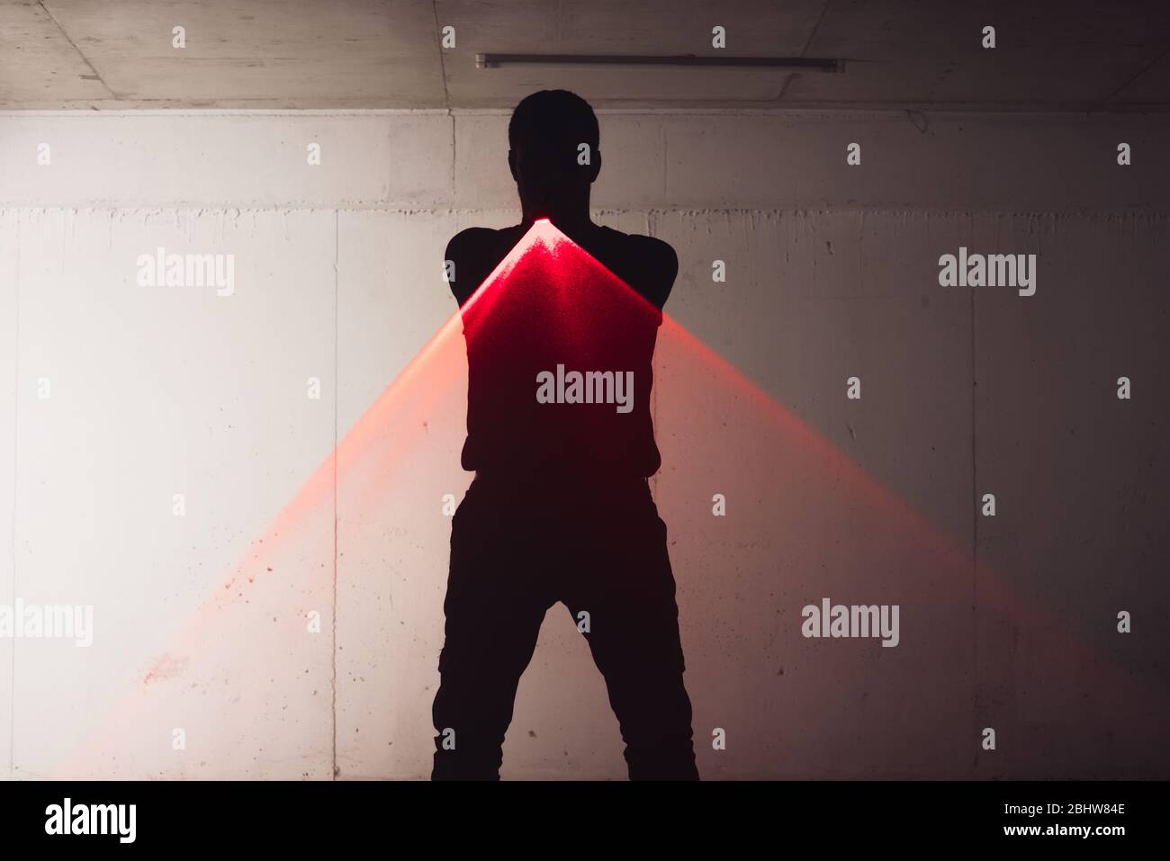 silhouette of an armed man holding his gun and pointing with his laser ...