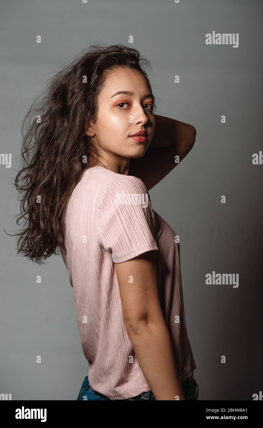 Portrait of a beautiful female model posing in trendy rose gold top ...