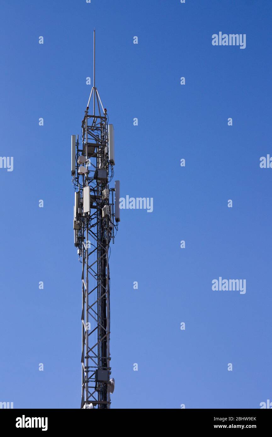 Image of a mobile phone antenna with a clear blue sky in the background ...