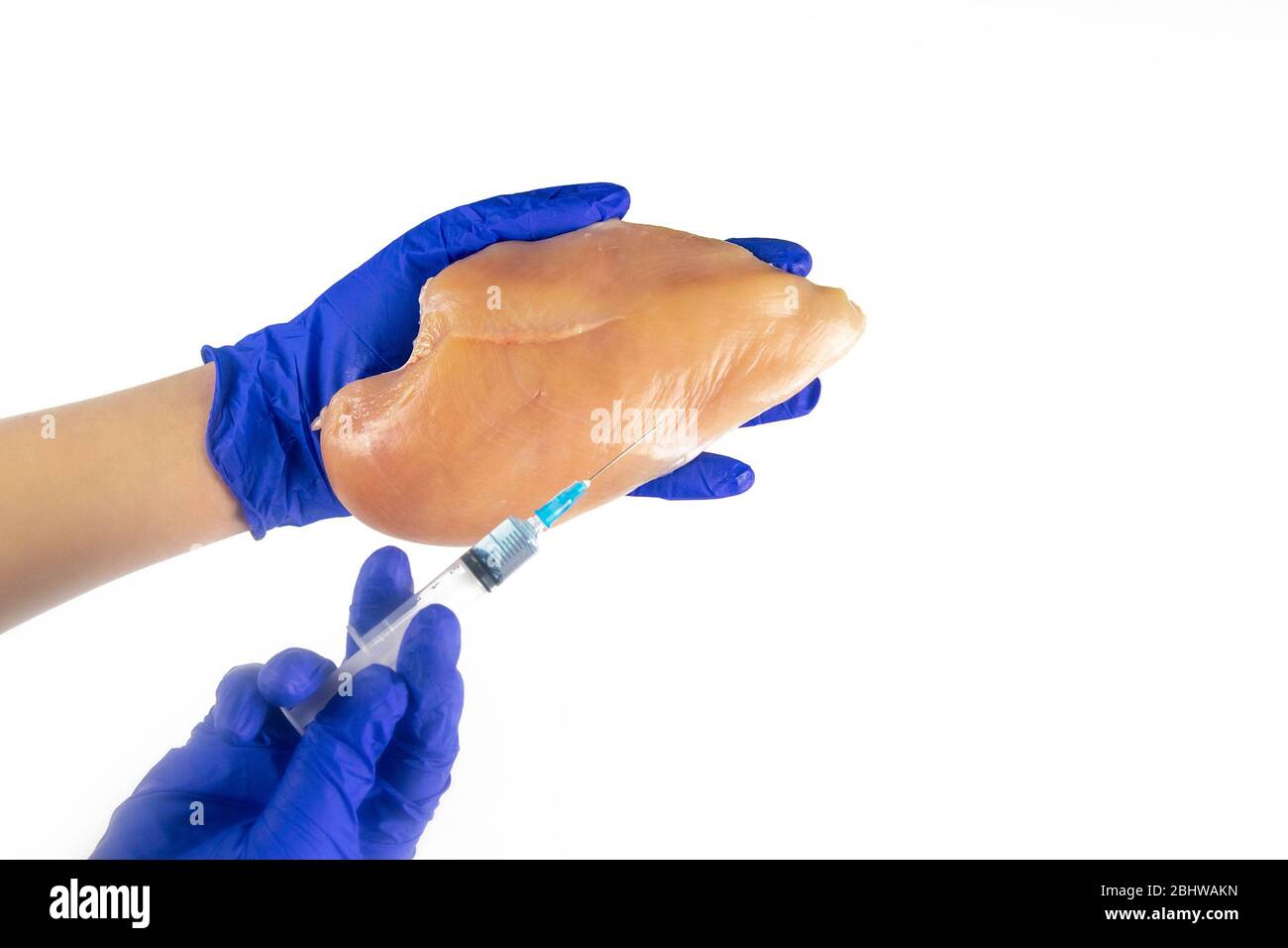 People make injection syringe in chicken fillet on white background ...
