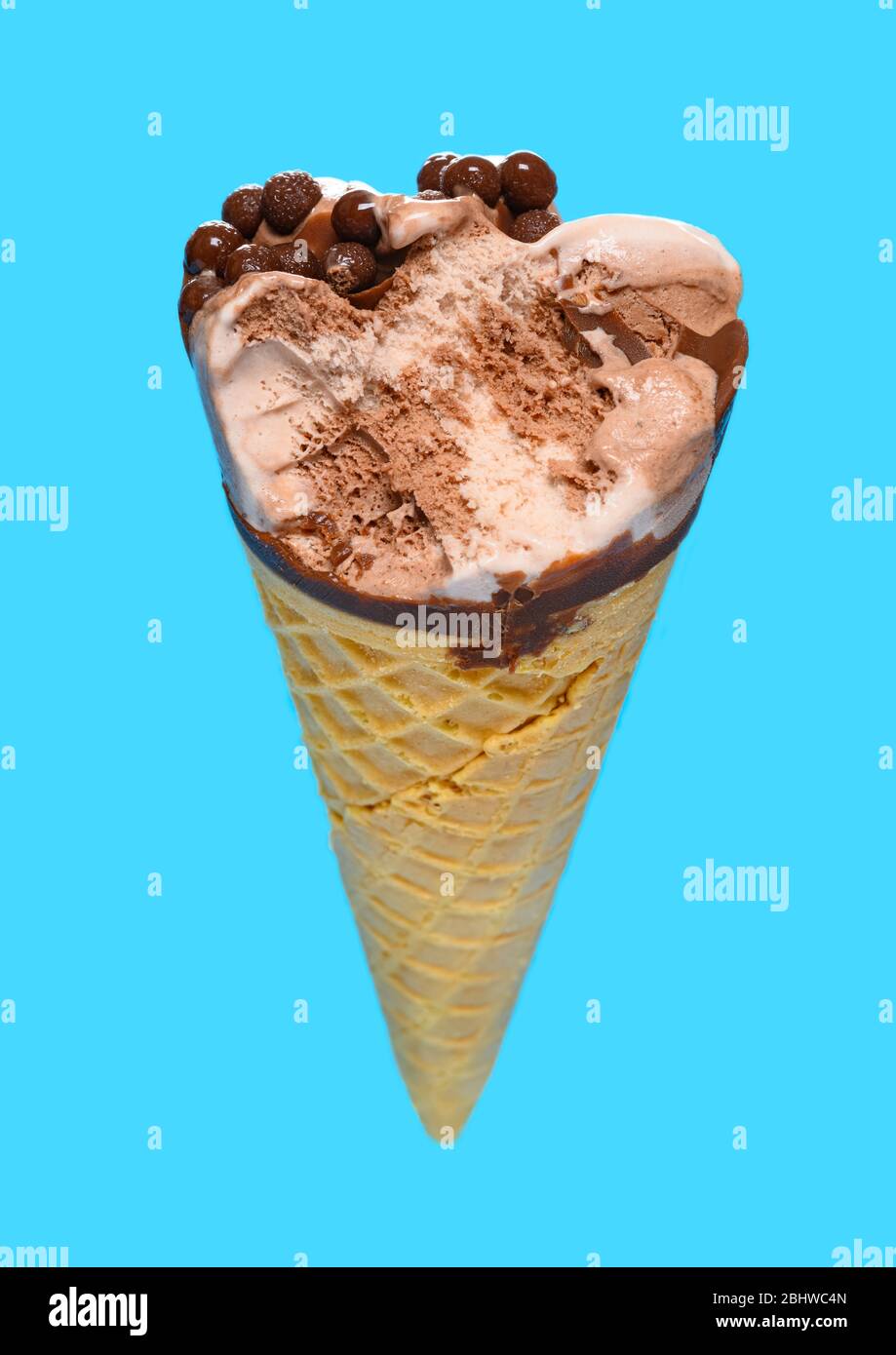angle view chocolate flavor ice cream cone with a bite on a blue ...
