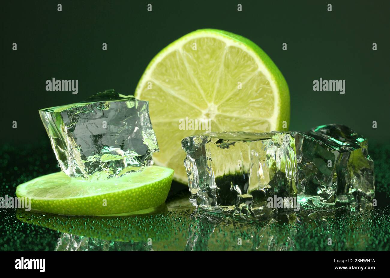 Ice cubes with lime on darck green background Stock Photo - Alamy