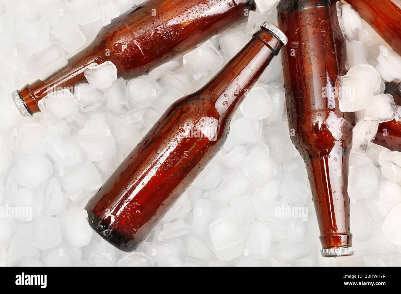 Glass bottles of beer with ice cubes, closeup Stock Photo - Alamy