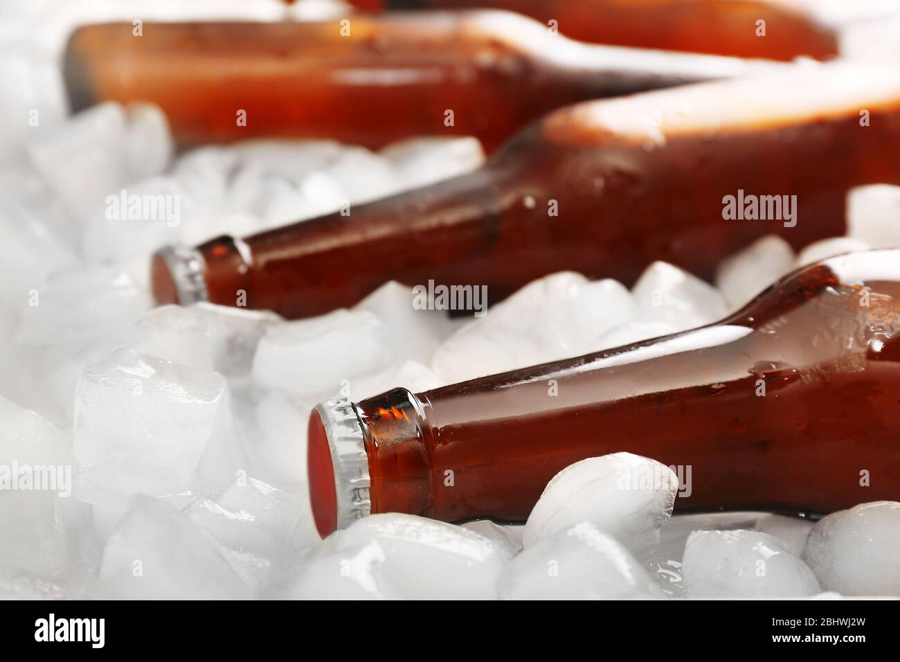 Glass bottles of beer with ice cubes, closeup Stock Photo - Alamy