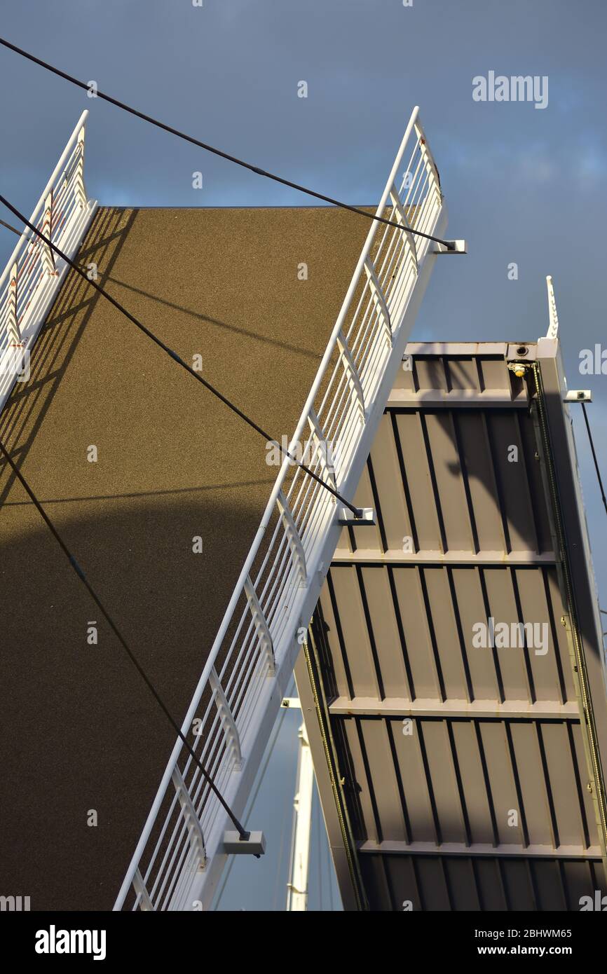 Double-leafed lifting bridge with white metal railing with both leaves ...