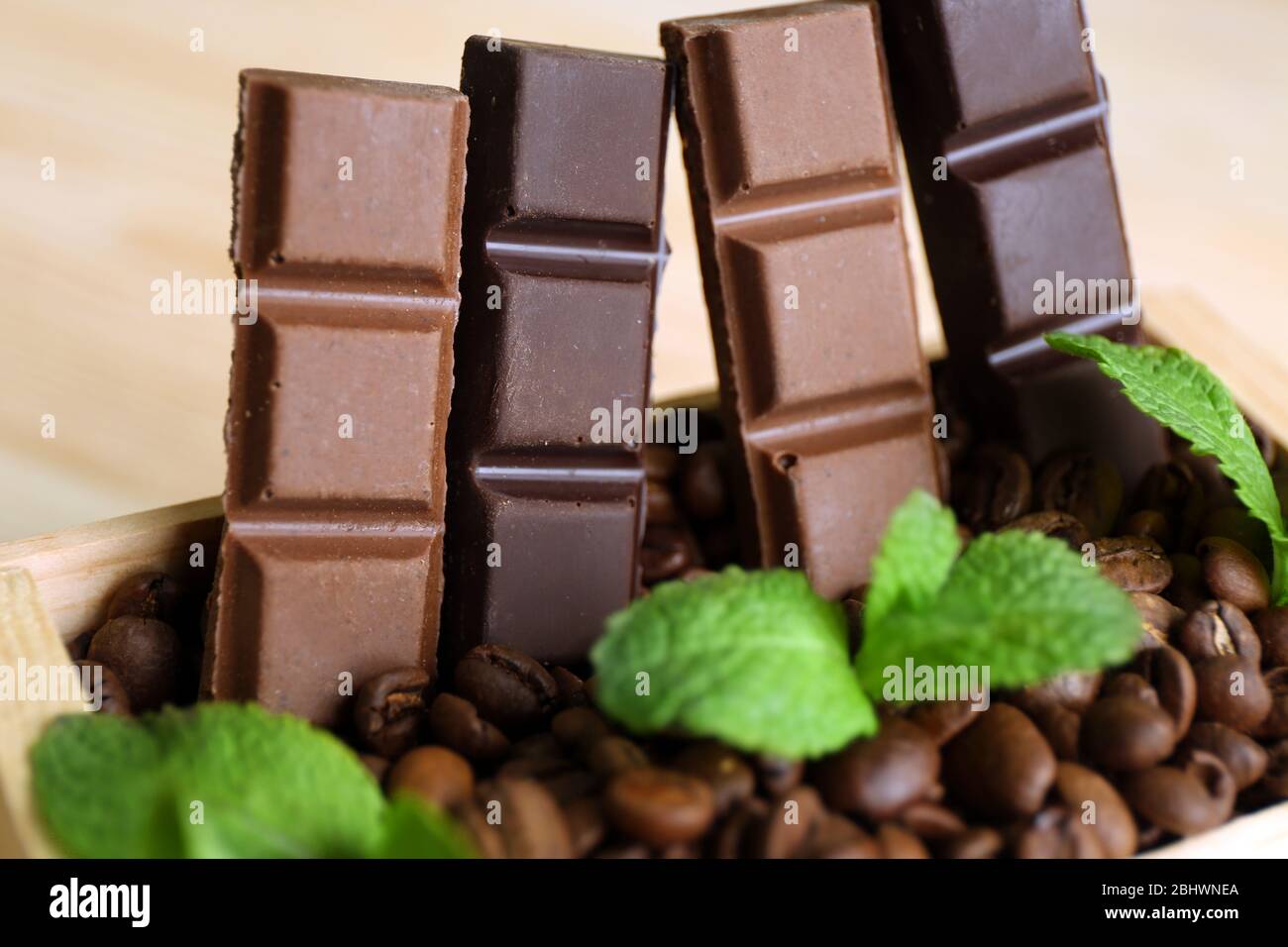 Still life with set of chocolate in wooden box of coffee grains ...