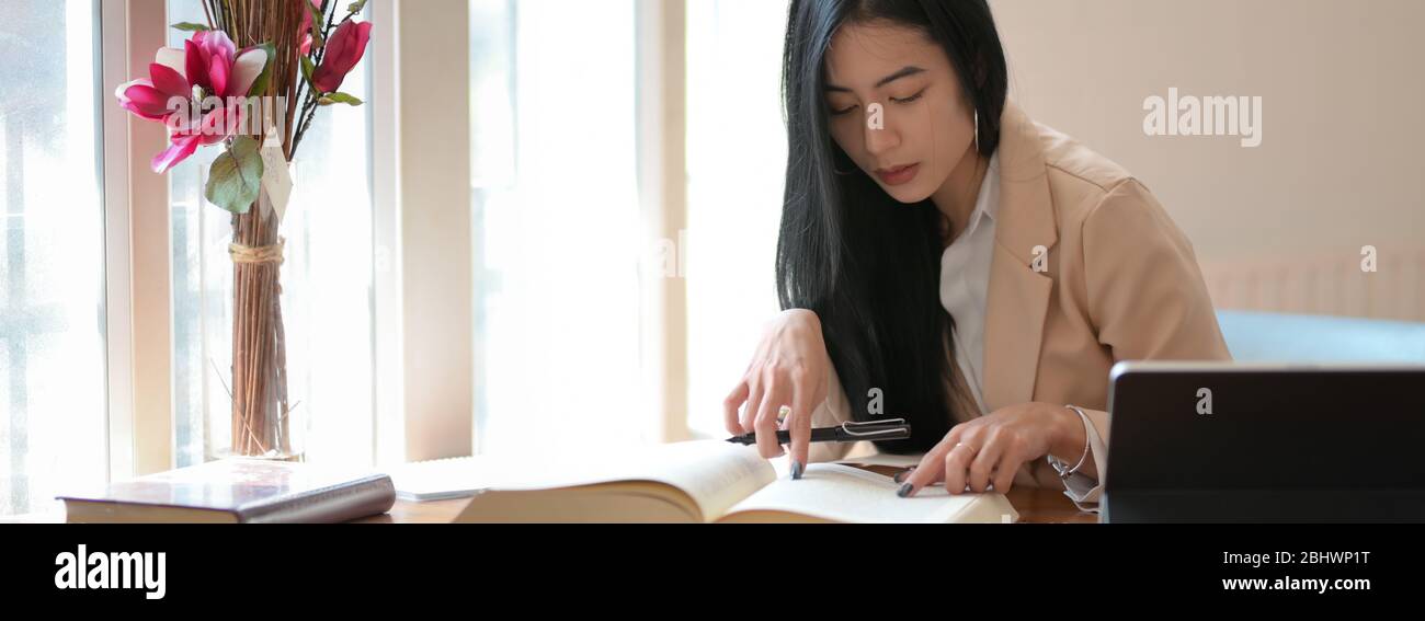 Close up view of professor reading book to prepare her teaching for ...