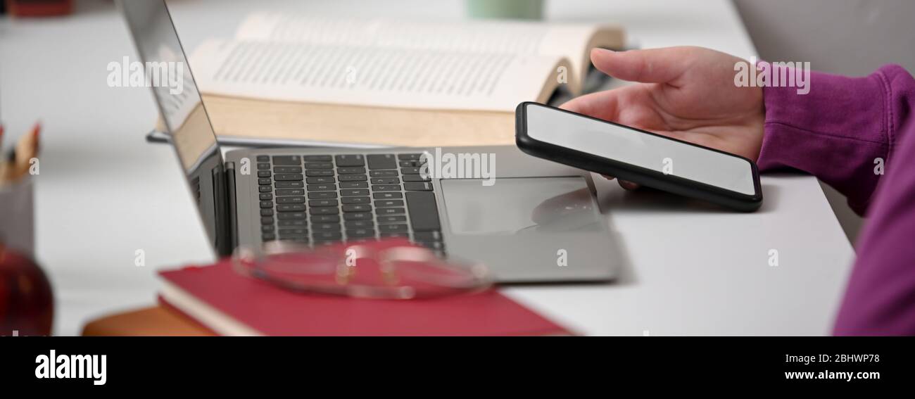 Side view of college student relaxing with mock-up smartphone while ...