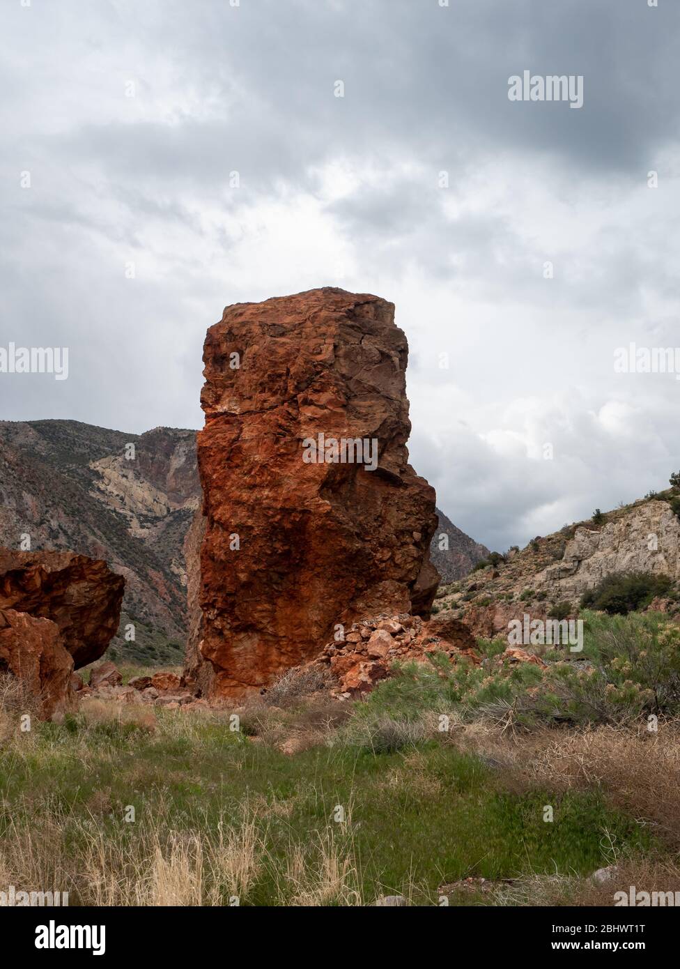 Large red vertically standing rock in the stormy desert of Nevada Stock ...