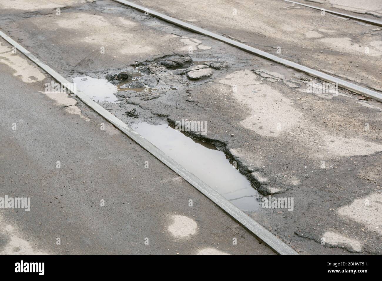 Very bad quality road with potholes and puddles Stock Photo - Alamy