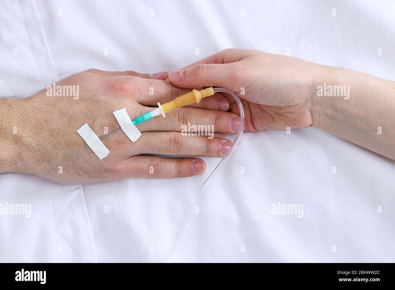 Female hand holding man hand with dropper needle on bed close-up Stock ...