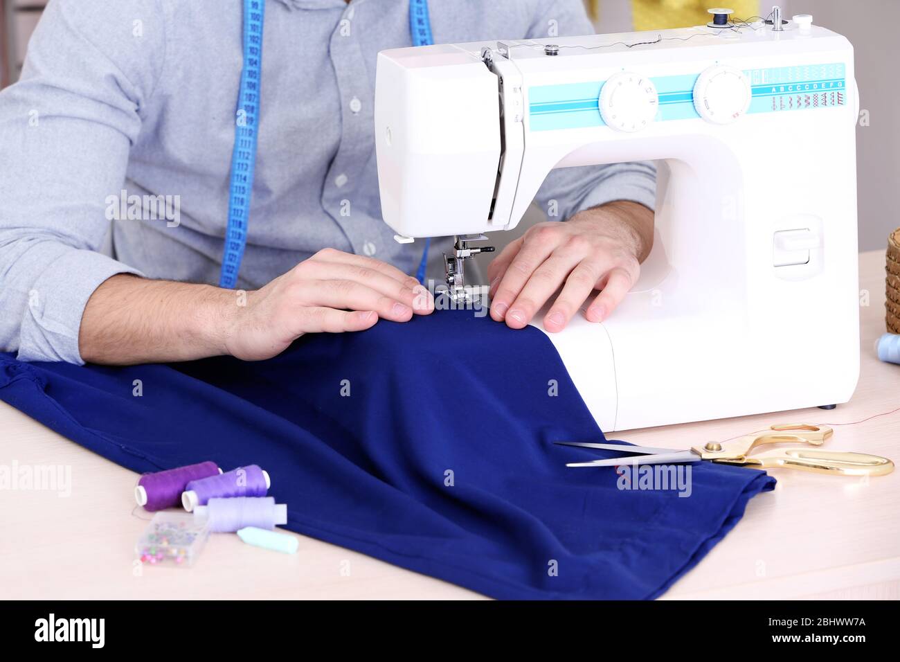 Man direct fabric in sewing machine Stock Photo - Alamy