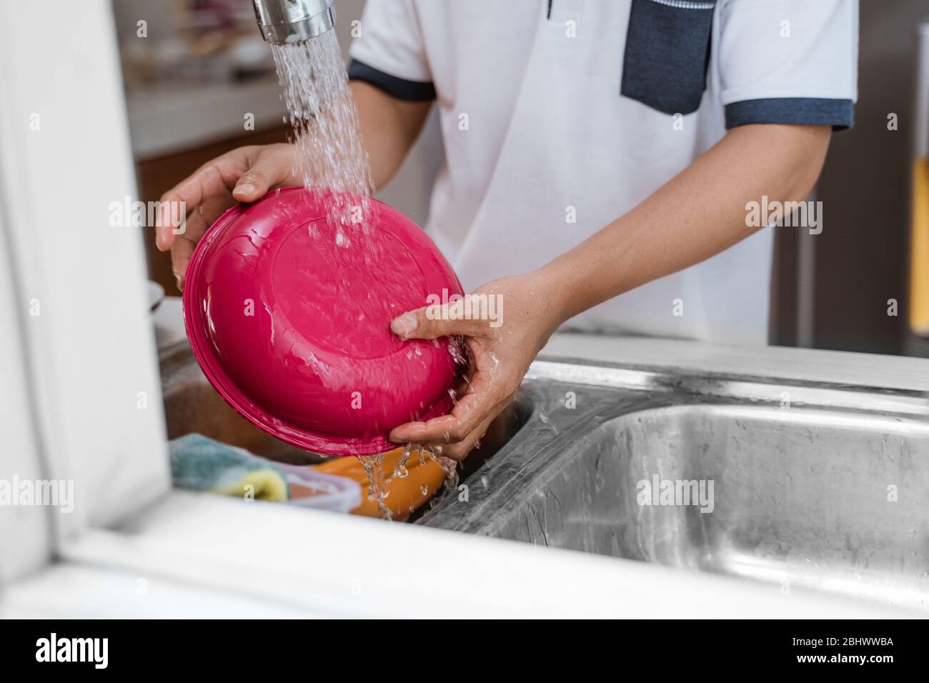 close up of hand rinse the plate in the kitchen sink Stock Photo - Alamy