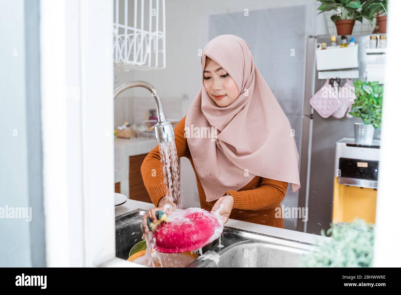 muslim woman doing chores and washing the dishes Stock Photo - Alamy