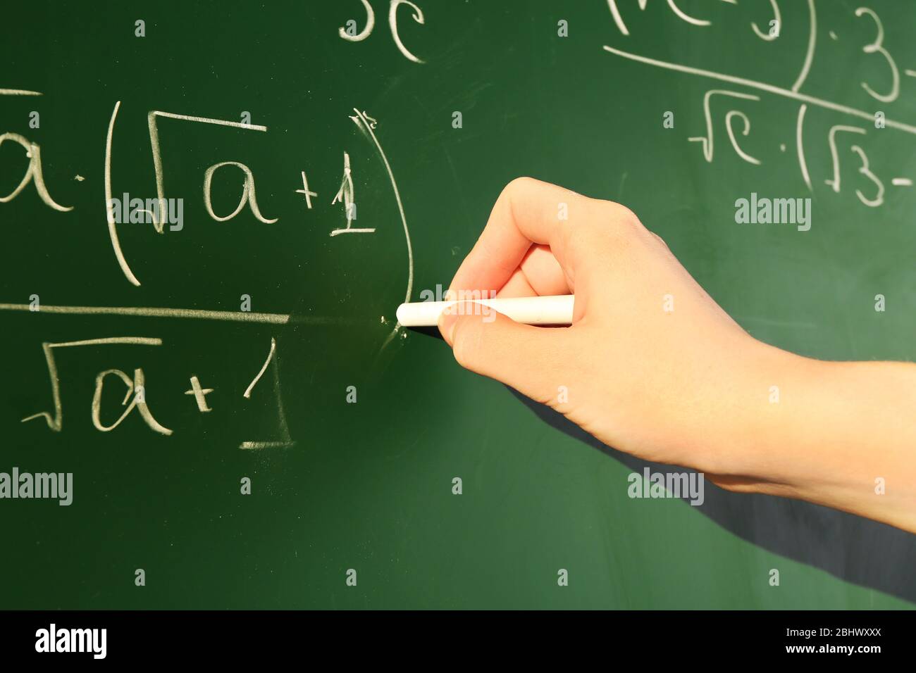 Teacher hand writing formulas on blackboard background Stock Photo - Alamy