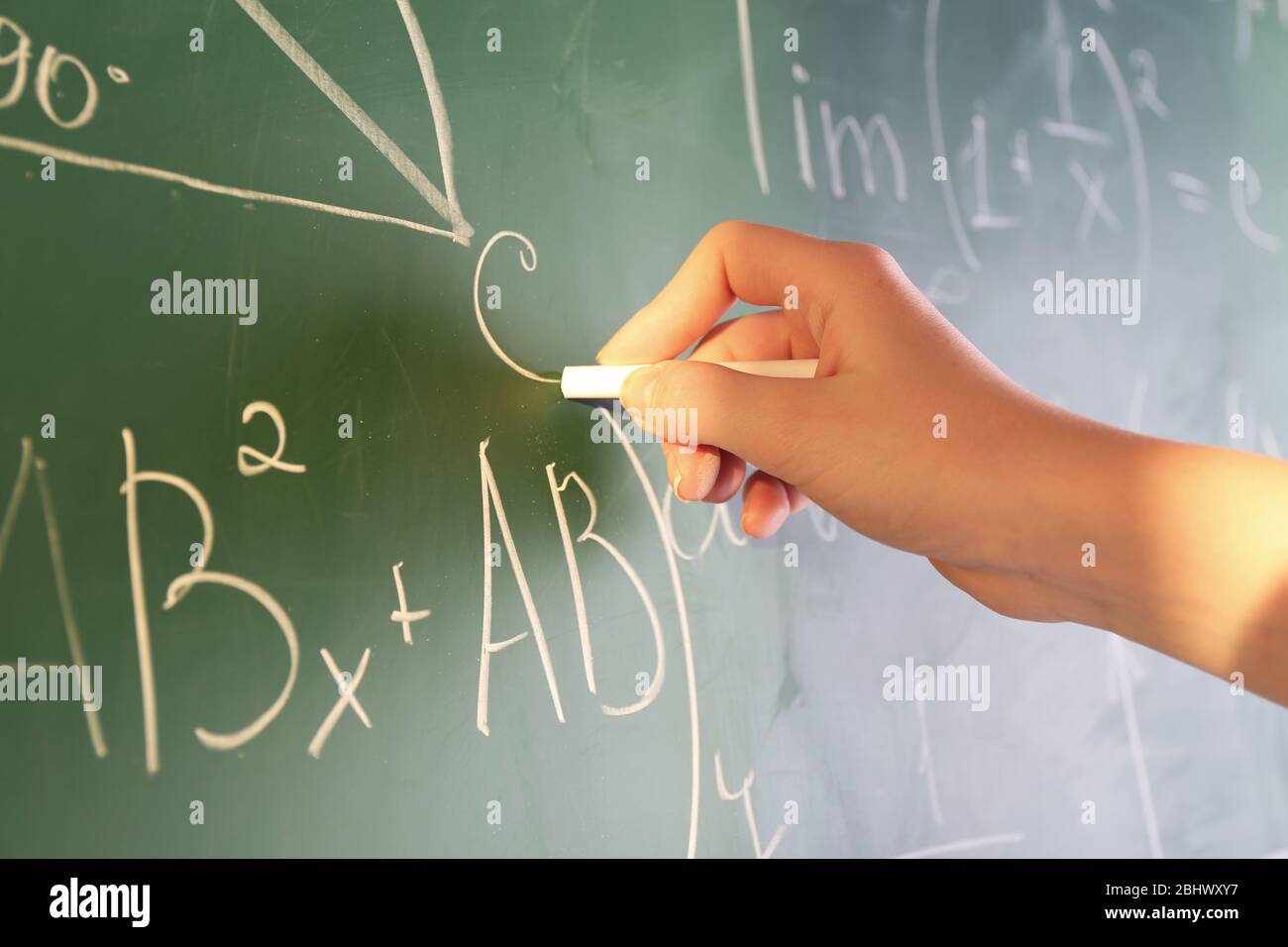 Teacher hand writing formulas on blackboard background Stock Photo - Alamy