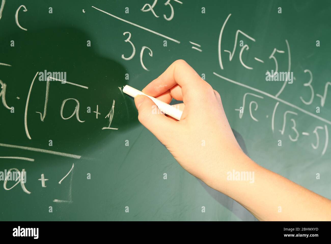 Teacher hand writing formulas on blackboard background Stock Photo - Alamy