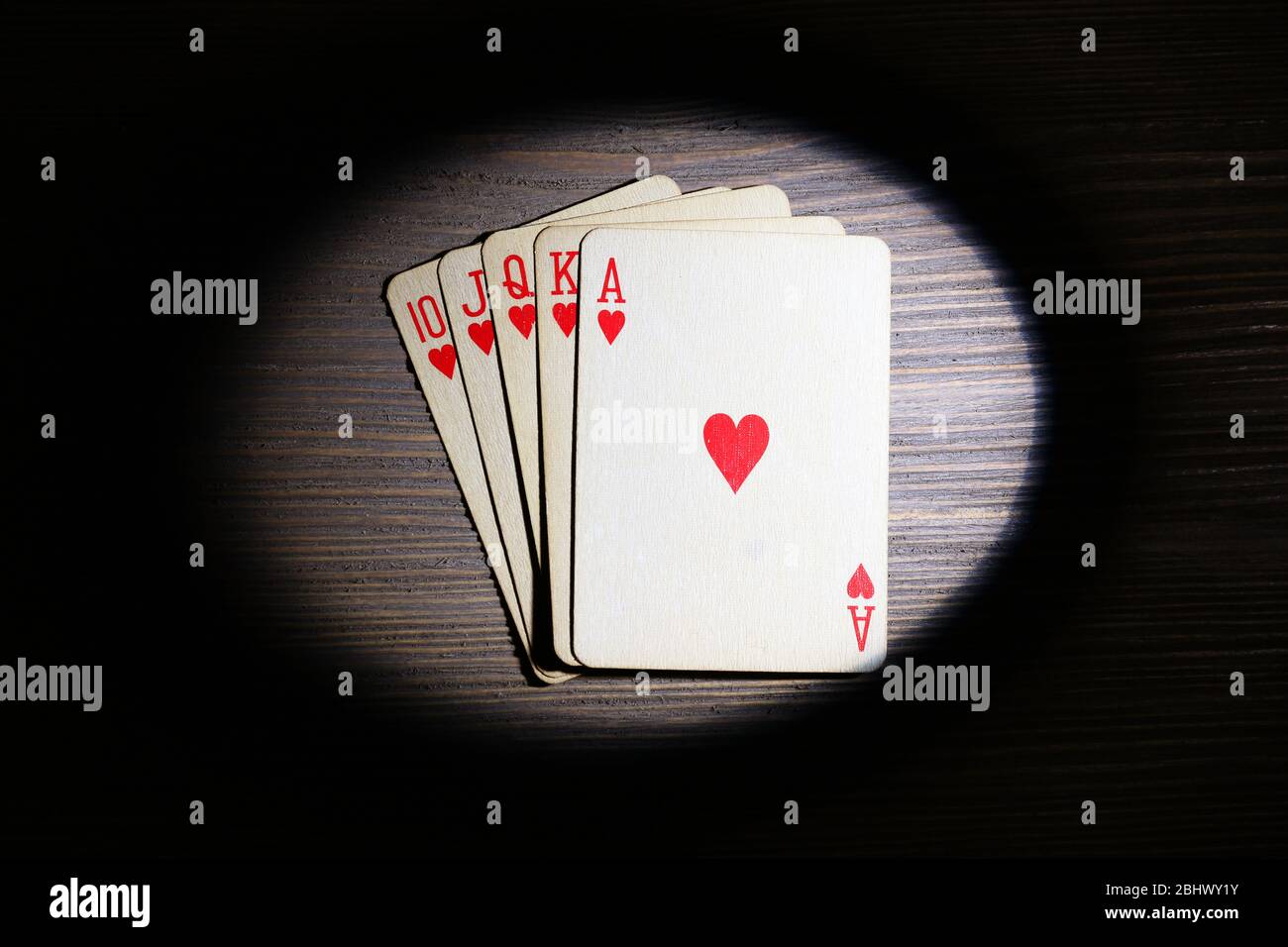 Playing cards in light on wooden table, top view Stock Photo - Alamy