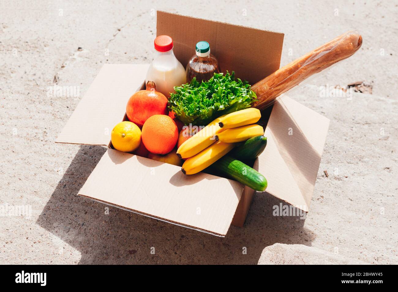A box of different food on the ground in front of the house. Safe home ...