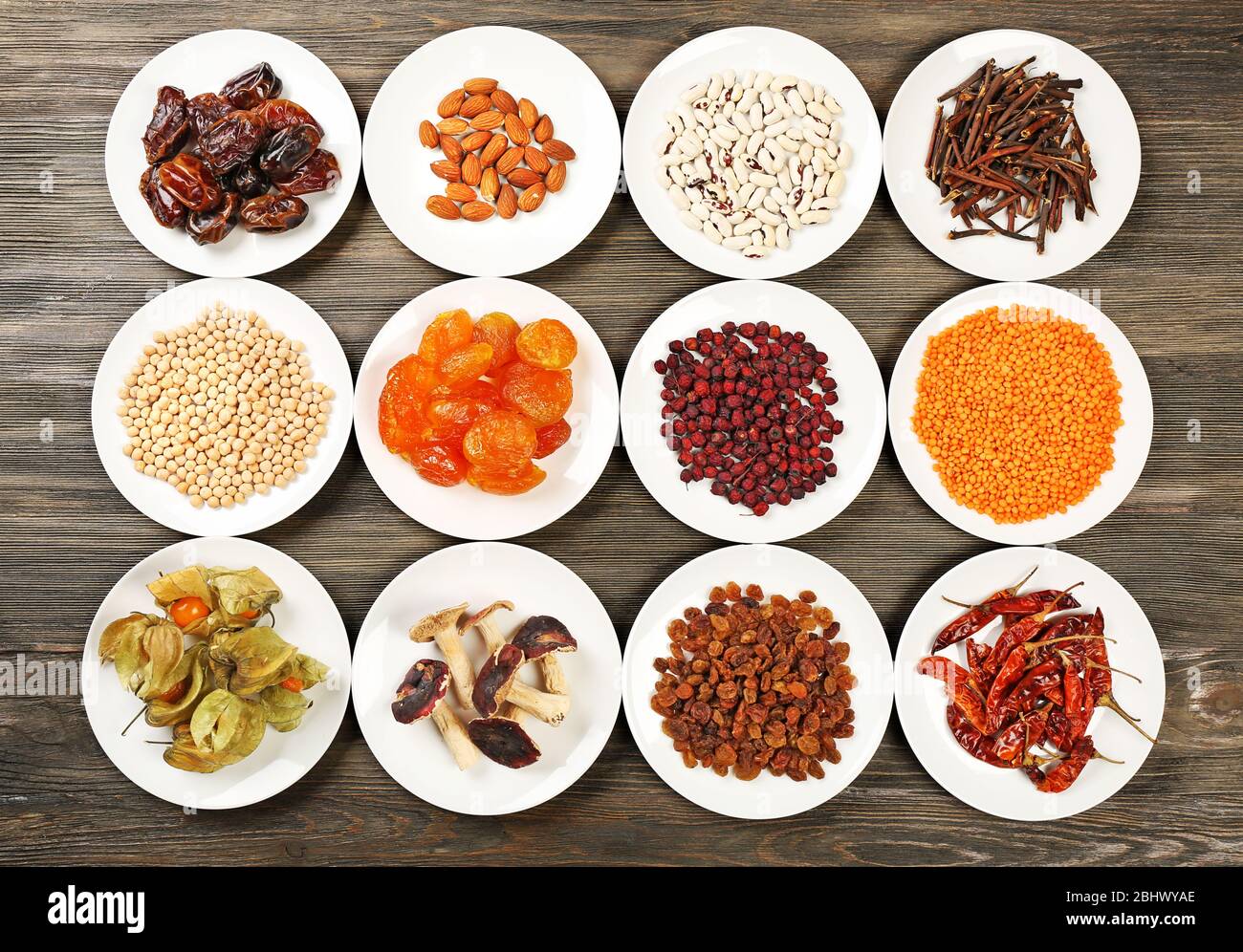 Different products on saucers on wooden background Stock Photo - Alamy