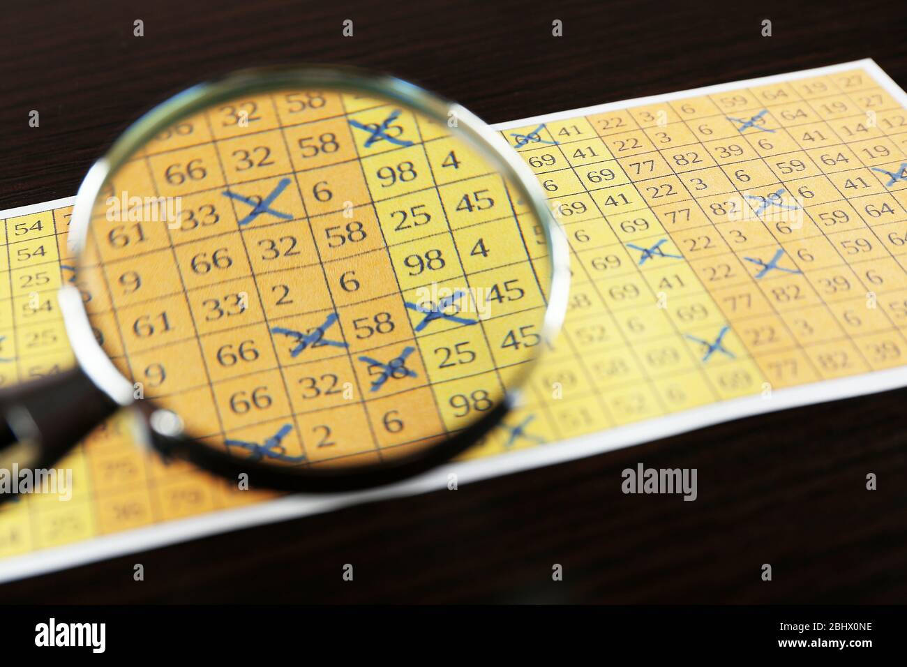 Analyzing lottery ticket with magnifier, closeup Stock Photo - Alamy