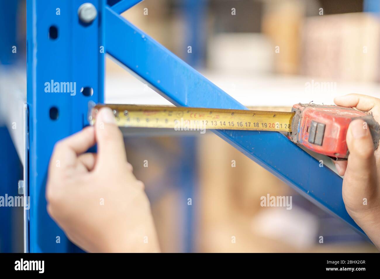 Male hand use the tape measure prepare to assembling the metal rack in ...