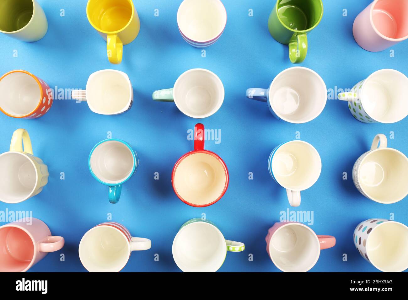 Group of colorful cups on color table, top view Stock Photo - Alamy