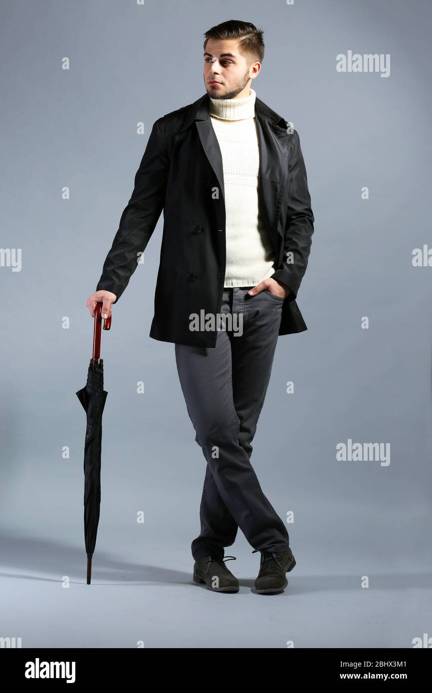 Elegant man with umbrella on gray background Stock Photo - Alamy