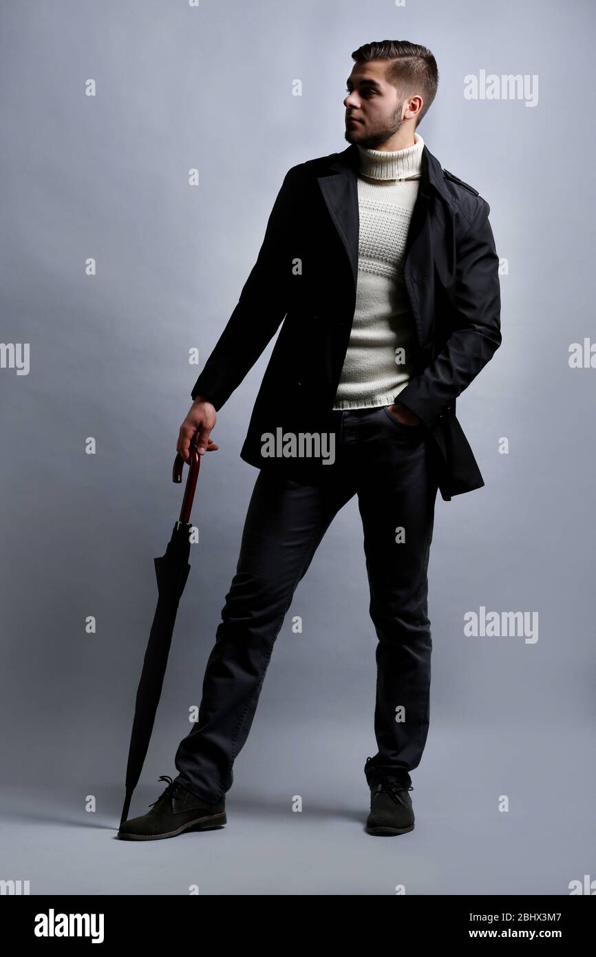 Elegant man with umbrella on gray background Stock Photo - Alamy