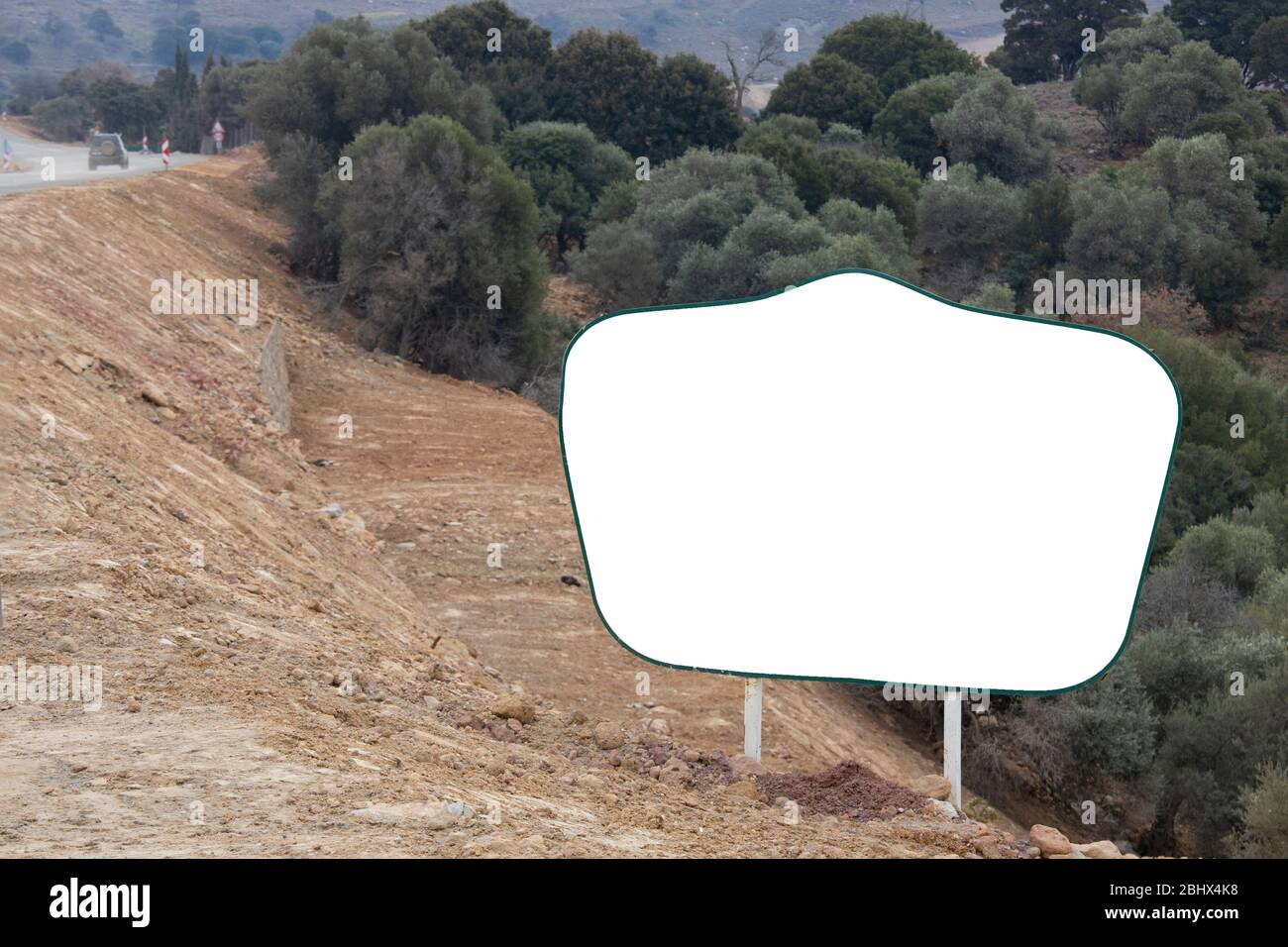 White curved advertising sign. There are olive trees in the background ...