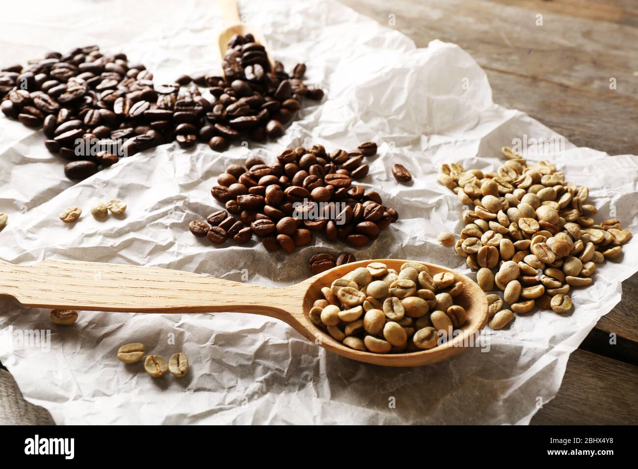 Coffee beans on crumpled parchment on wooden table, closeup Stock Photo ...