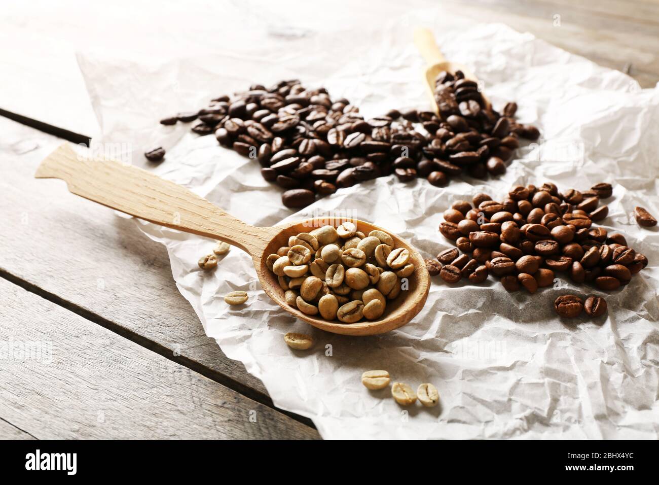 Coffee beans on crumpled parchment on wooden table, closeup Stock Photo ...