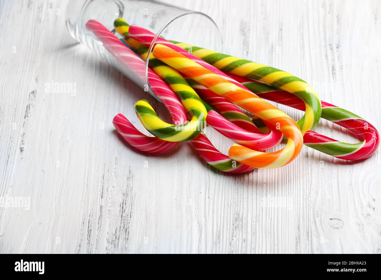 Colorful candy canes in glass on wooden background Stock Photo - Alamy