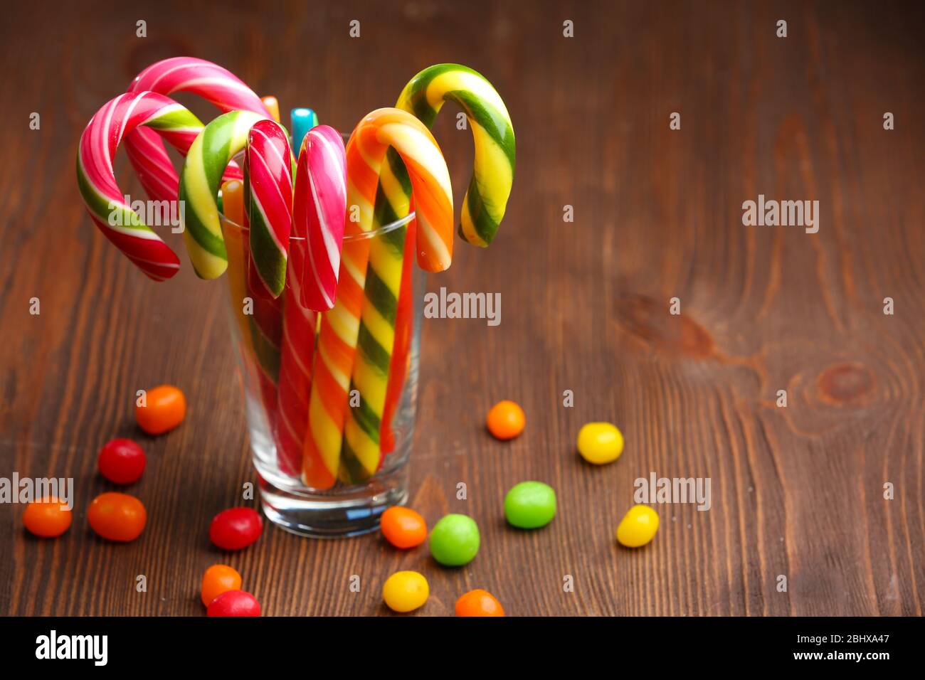 Colorful candy canes in glass on wooden background Stock Photo - Alamy