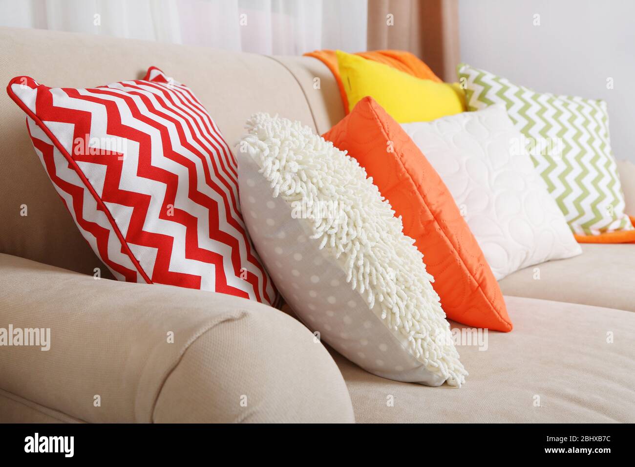 Sofa with colorful pillows in room Stock Photo - Alamy