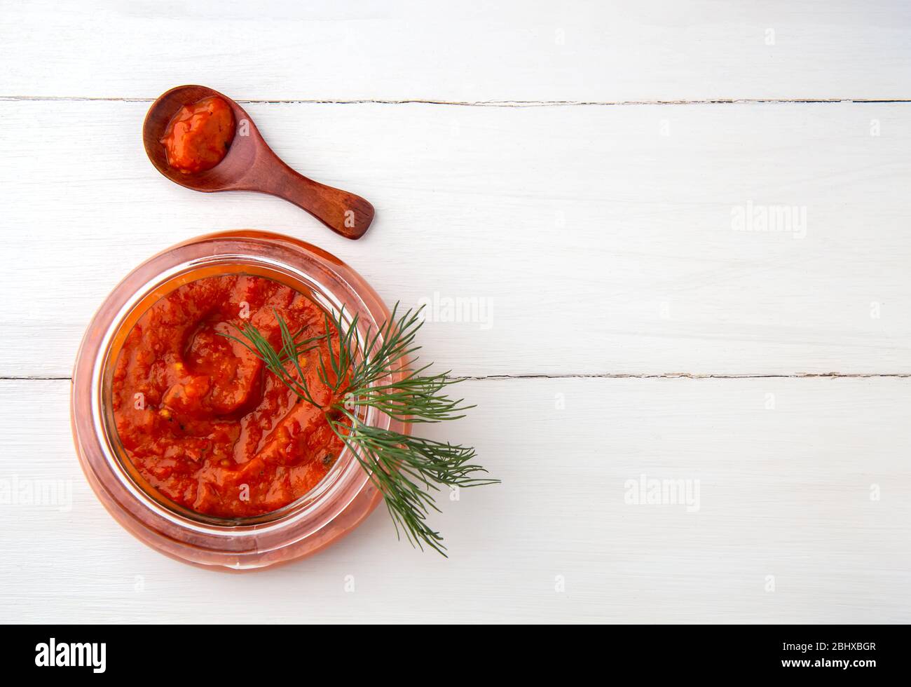 Balkan snack ajvar in a jar on a white background. Top view, copy space ...