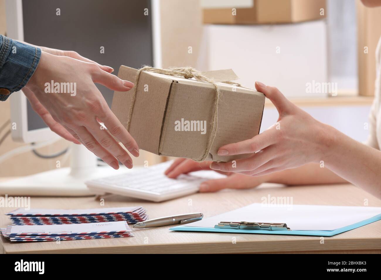 Woman gives parcel in post office Stock Photo - Alamy