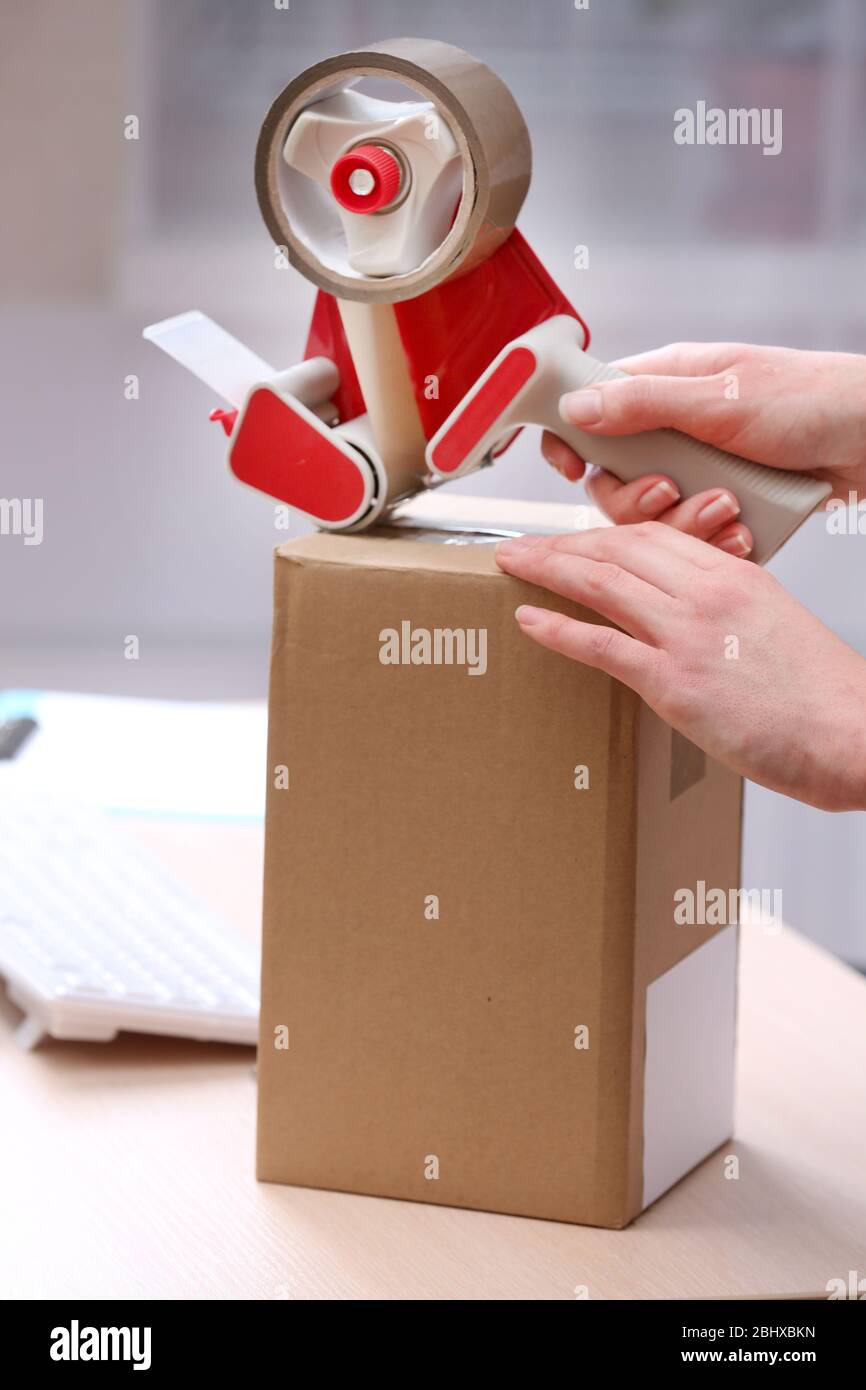Woman packs parcel in post office Stock Photo - Alamy