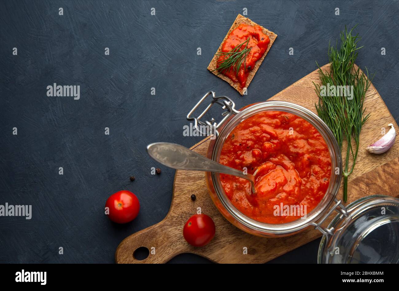 Balkan cuisine. Ajvar, pinjur, lutenitsa, harissa in the bank on a dark ...