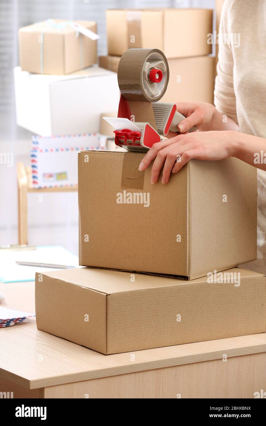 Woman packs parcel in post office Stock Photo - Alamy