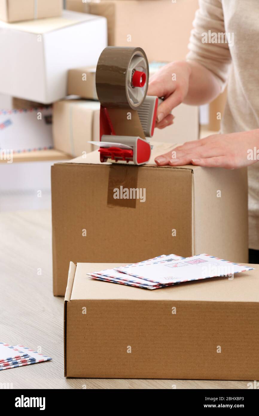 Woman packs parcel in post office Stock Photo - Alamy