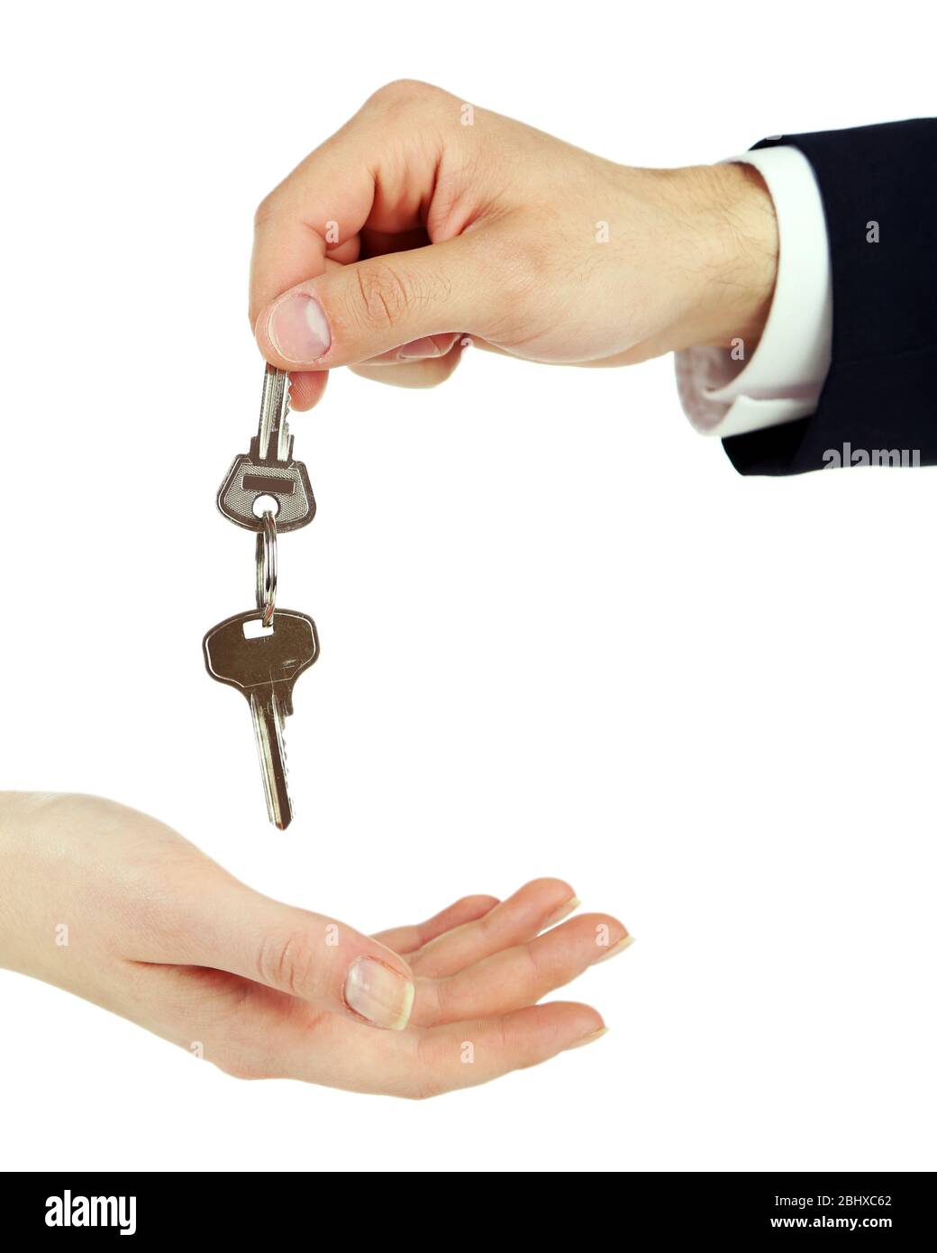 Male hand giving key with trinket to female hand isolated on white ...