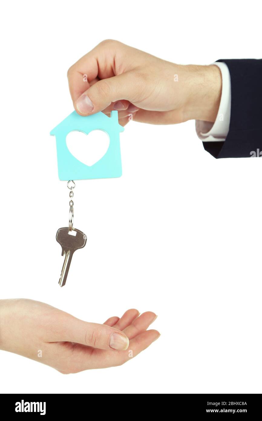 Male hand giving key with trinket to female hand isolated on white ...
