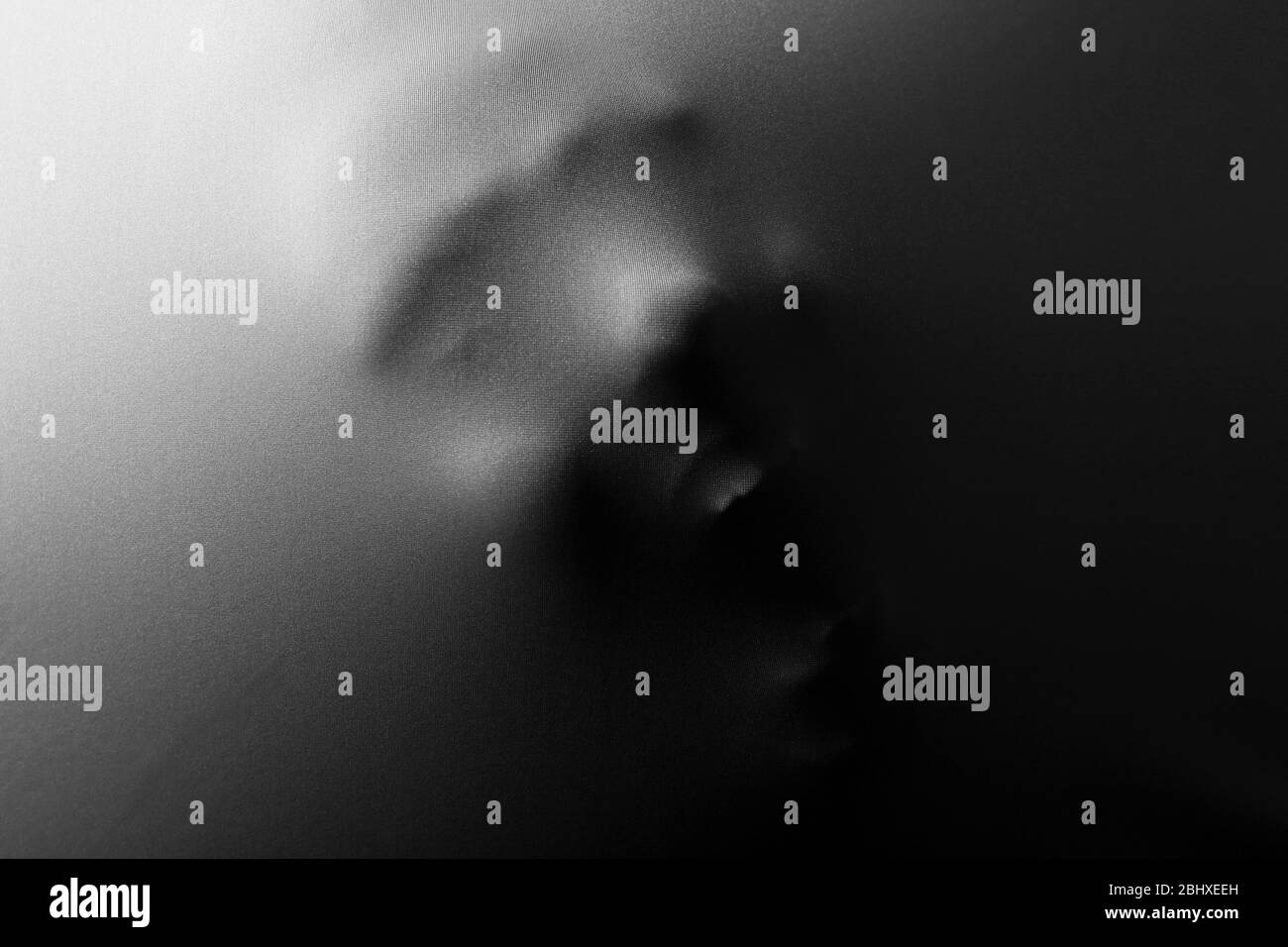 Screaming human face pressing through fabric as horror background Stock ...